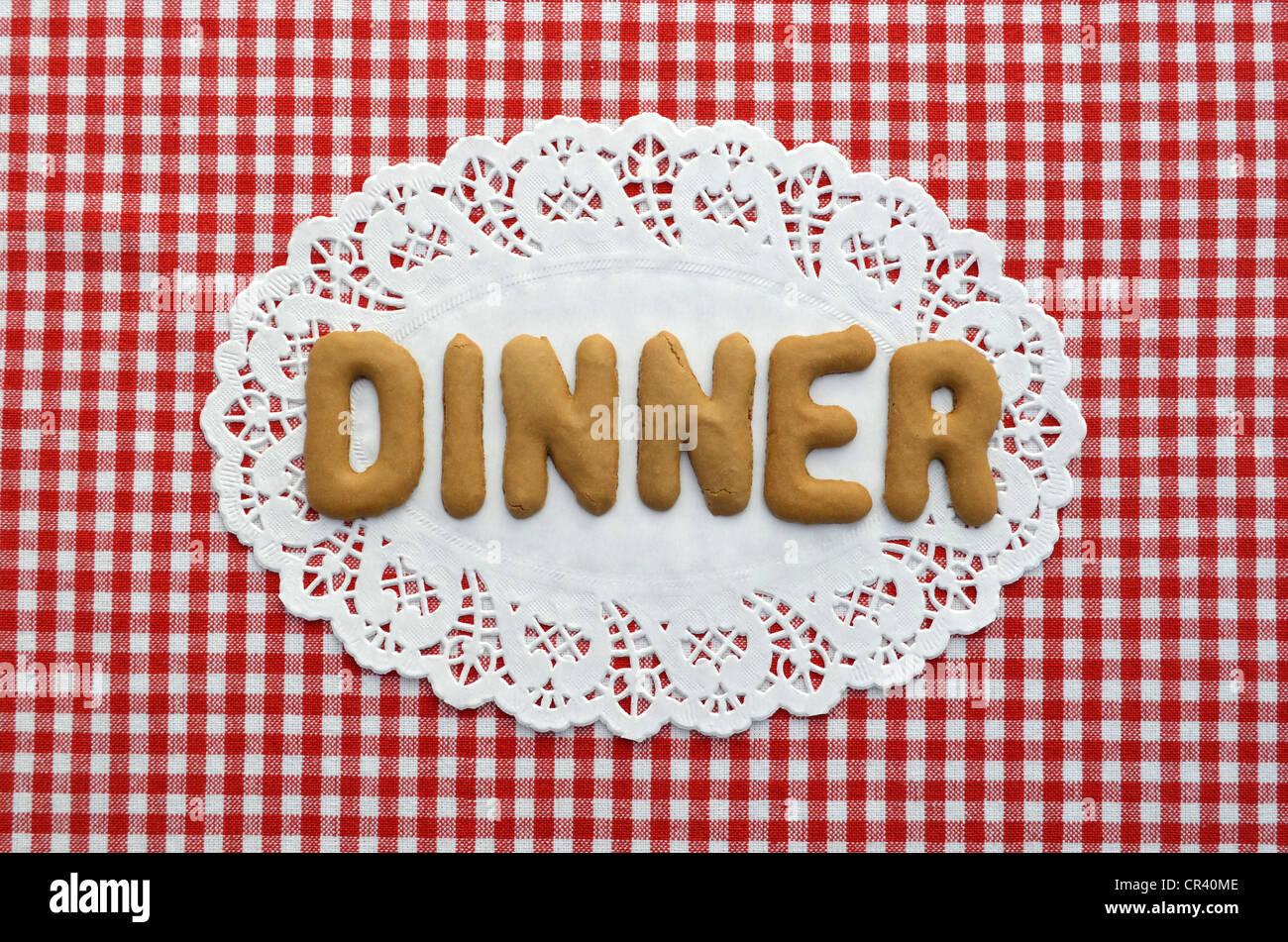 Dinner, written in alphabet biscuits on paper doily Stock Photo - Alamy