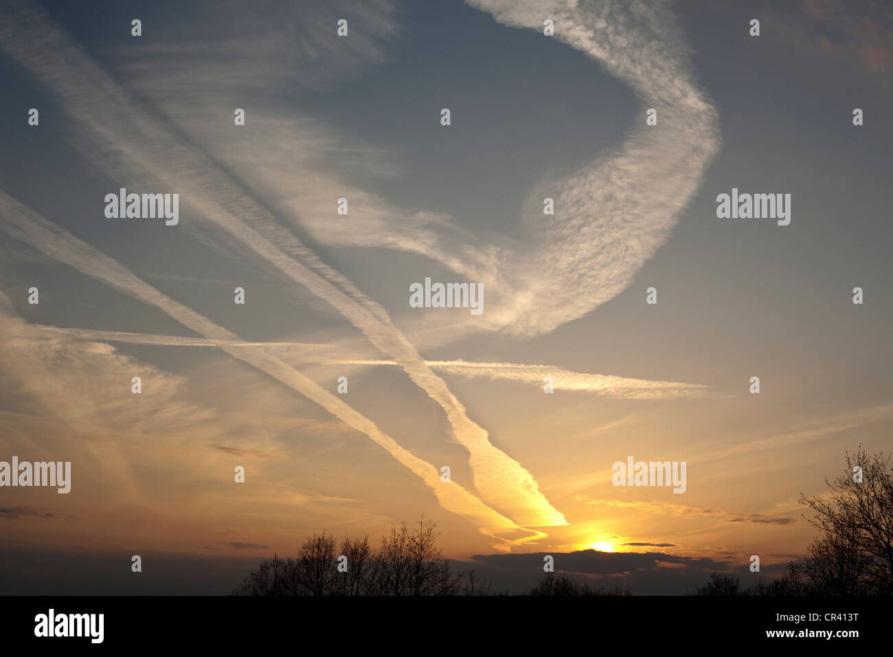 Plain trails in sky at sunset, England, UK Stock Photo - Alamy