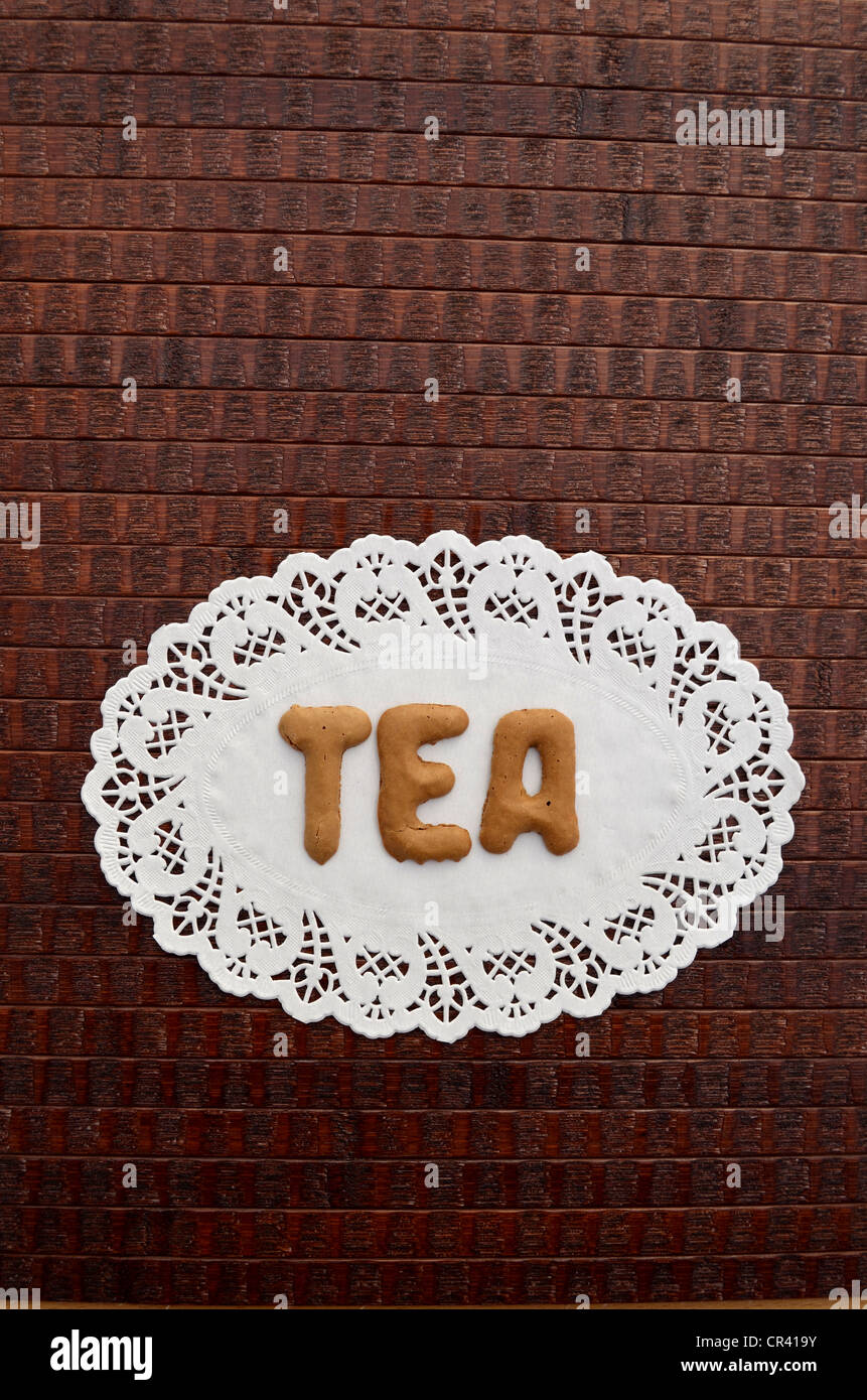 Tea, written with alphabet biscuits on a paper doily Stock Photo - Alamy