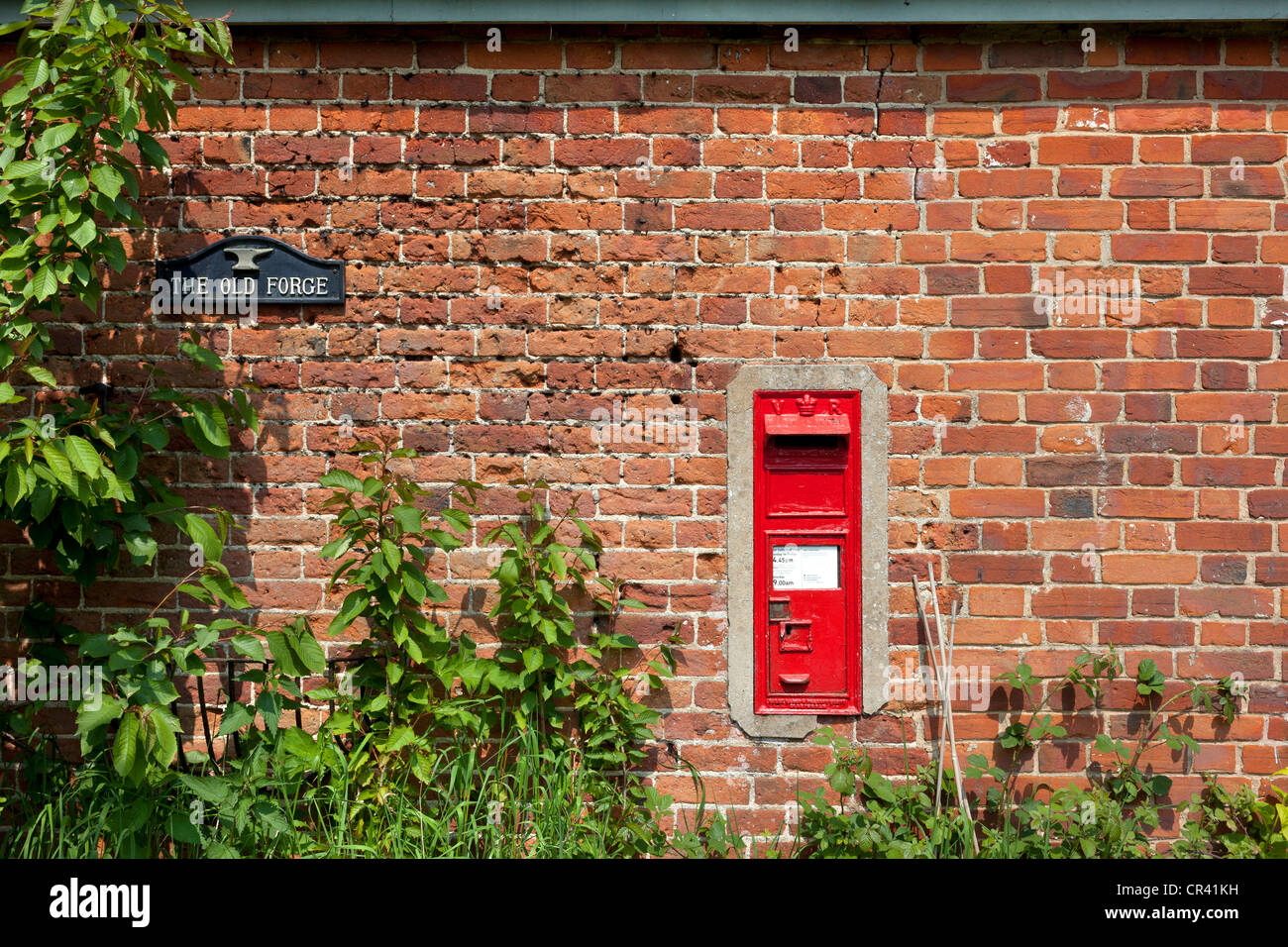 A postbox set in the wall of an old country village forge which is now ...