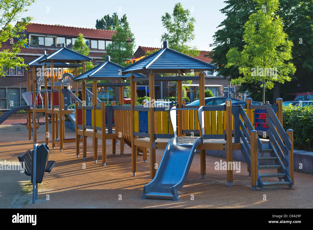 Public playground with colorful wooden climbing construction, swing ...