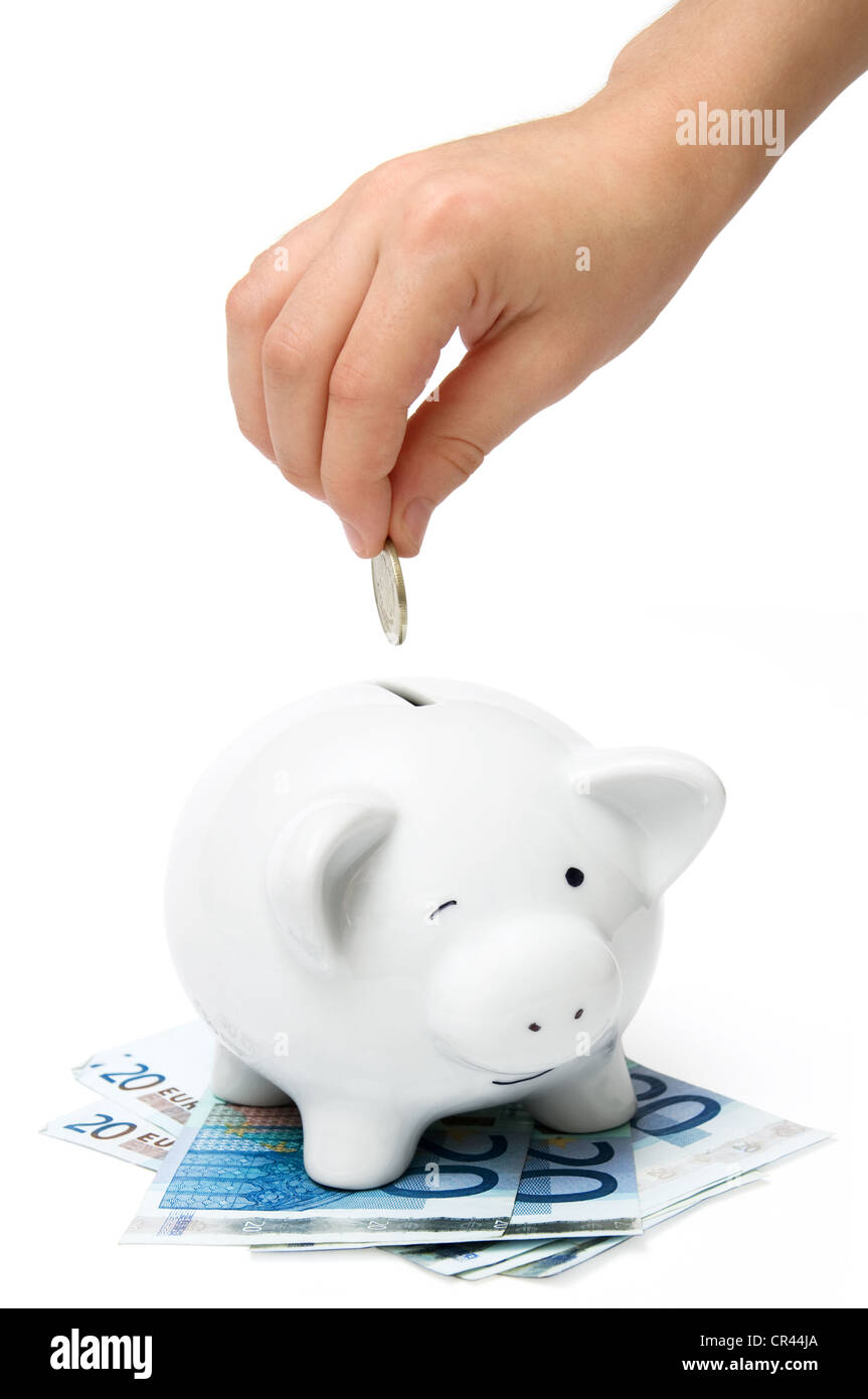 Hand inserting coin into piggybank isolated on white background Stock ...