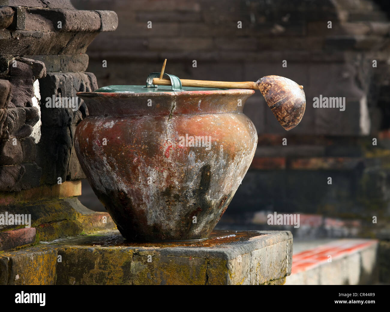 Ancient pot with a ladle before a temple for washing legs. Indonesia ...