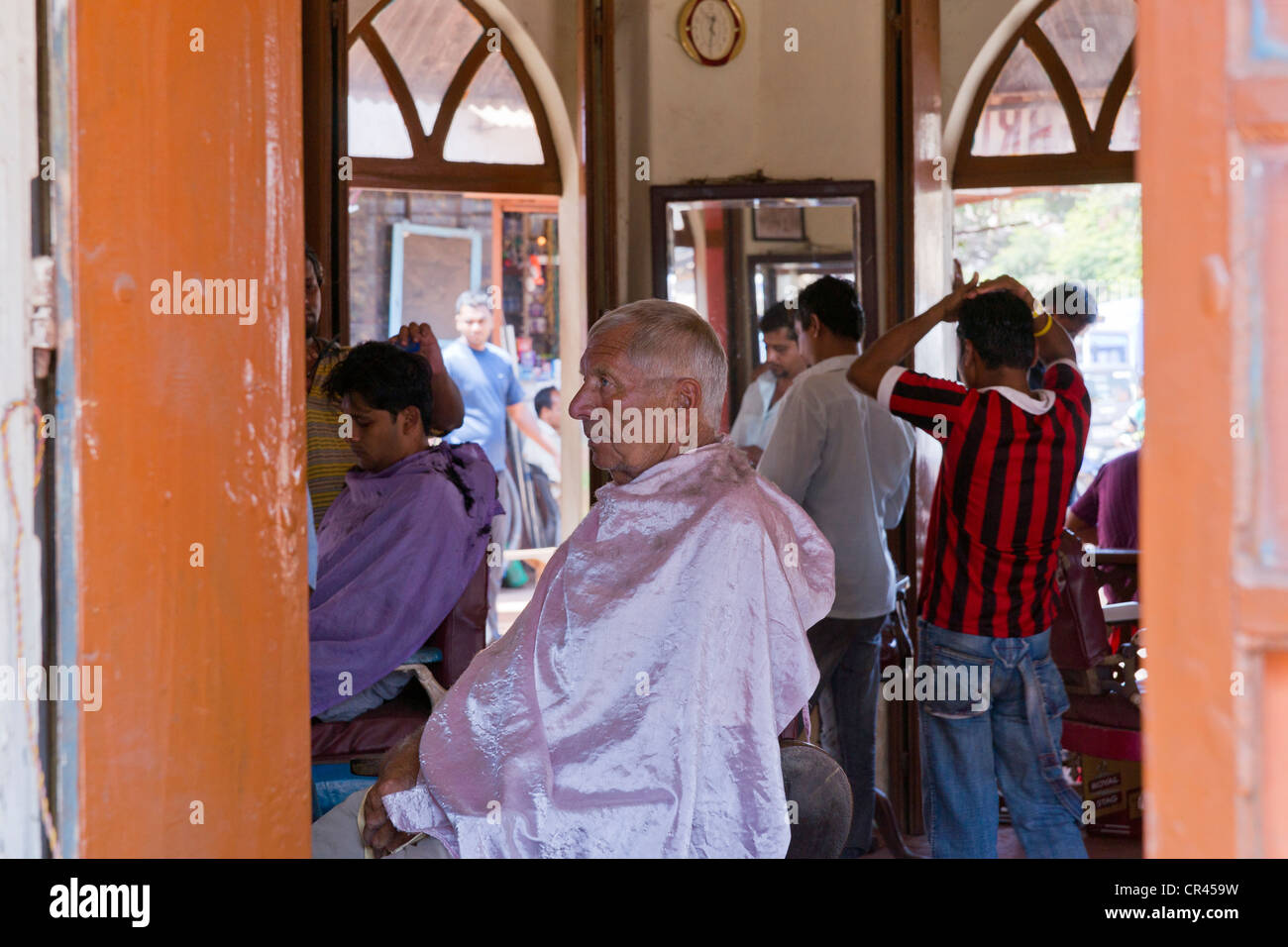 A man in an Indian barbers getting his hair cut Stock Photo - Alamy