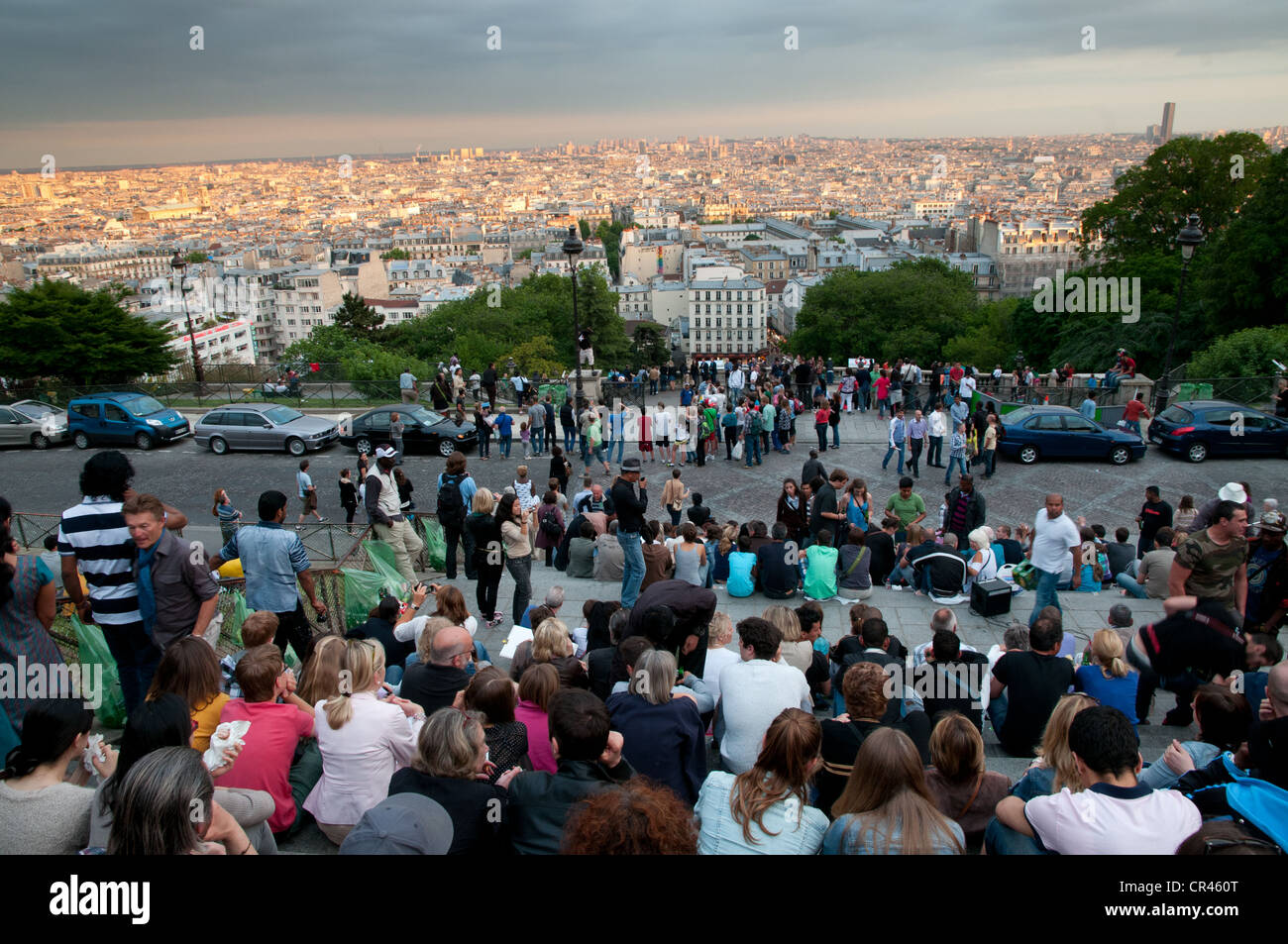 Crowd of people sitting on steps of Sacre Coeur watching sun set over ...