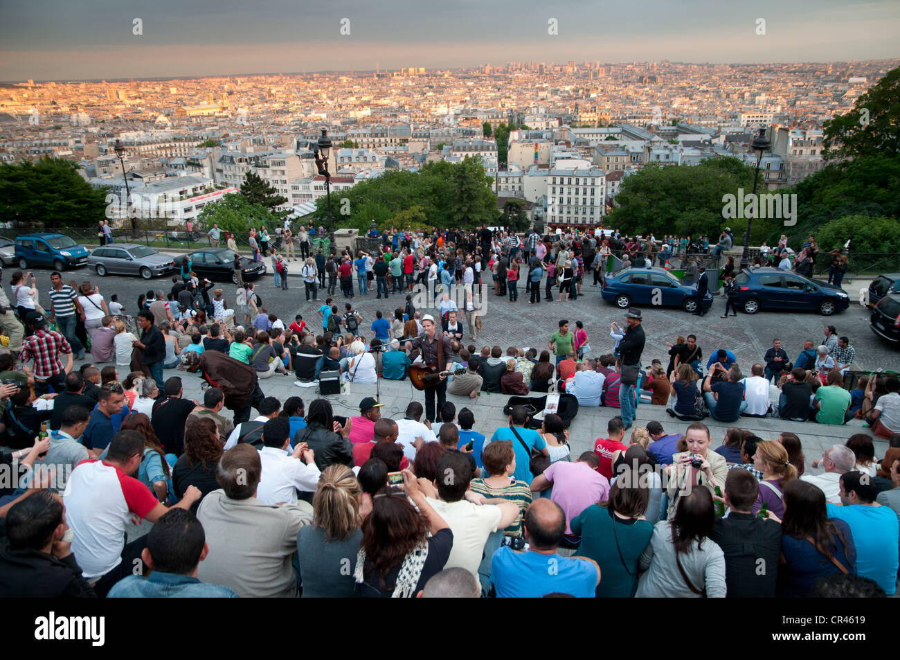 Crowd of people sitting on steps of Sacre Coeur watching sun set over ...