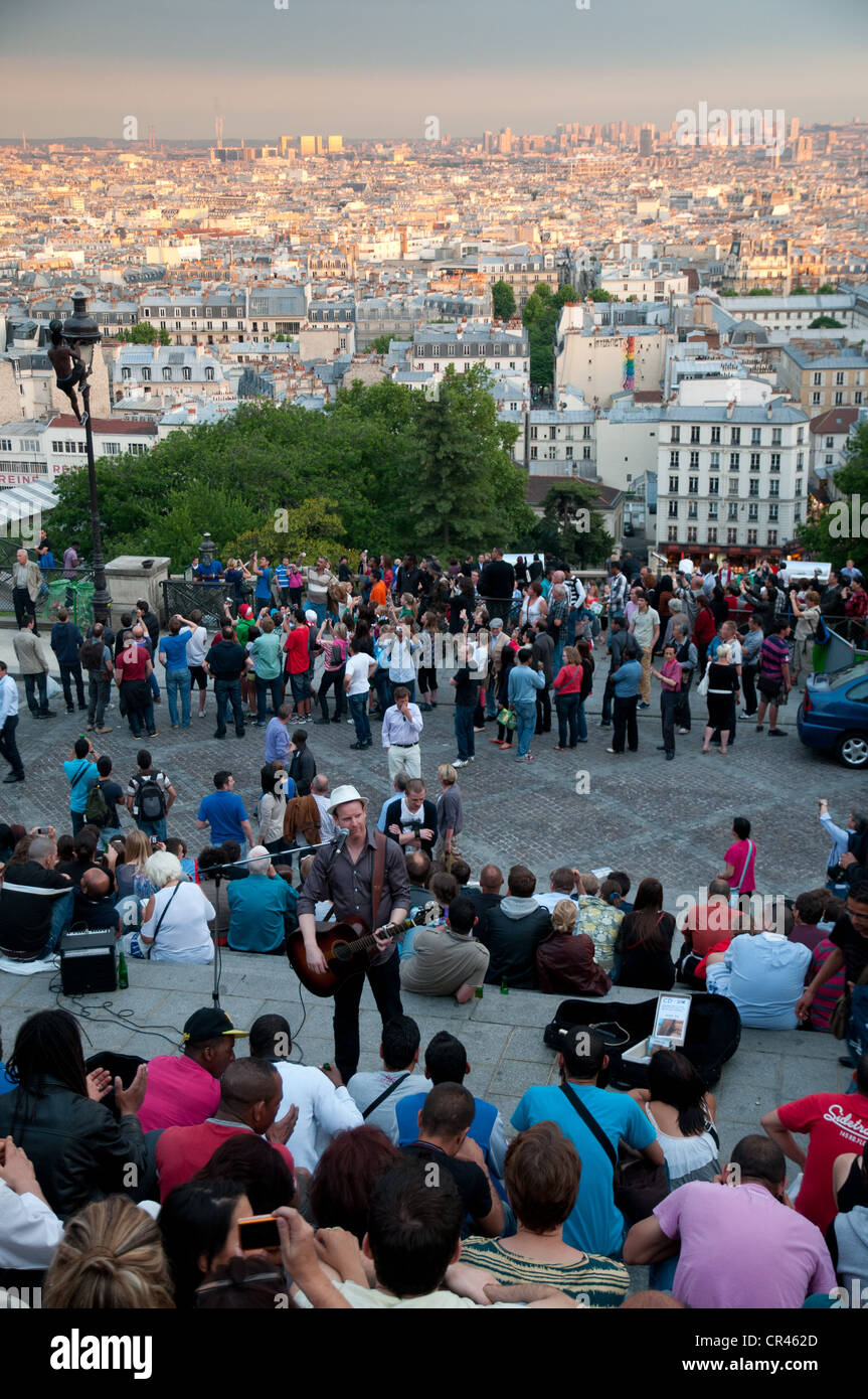 Crowd of people sitting on steps of Sacre Coeur watching sun set over ...