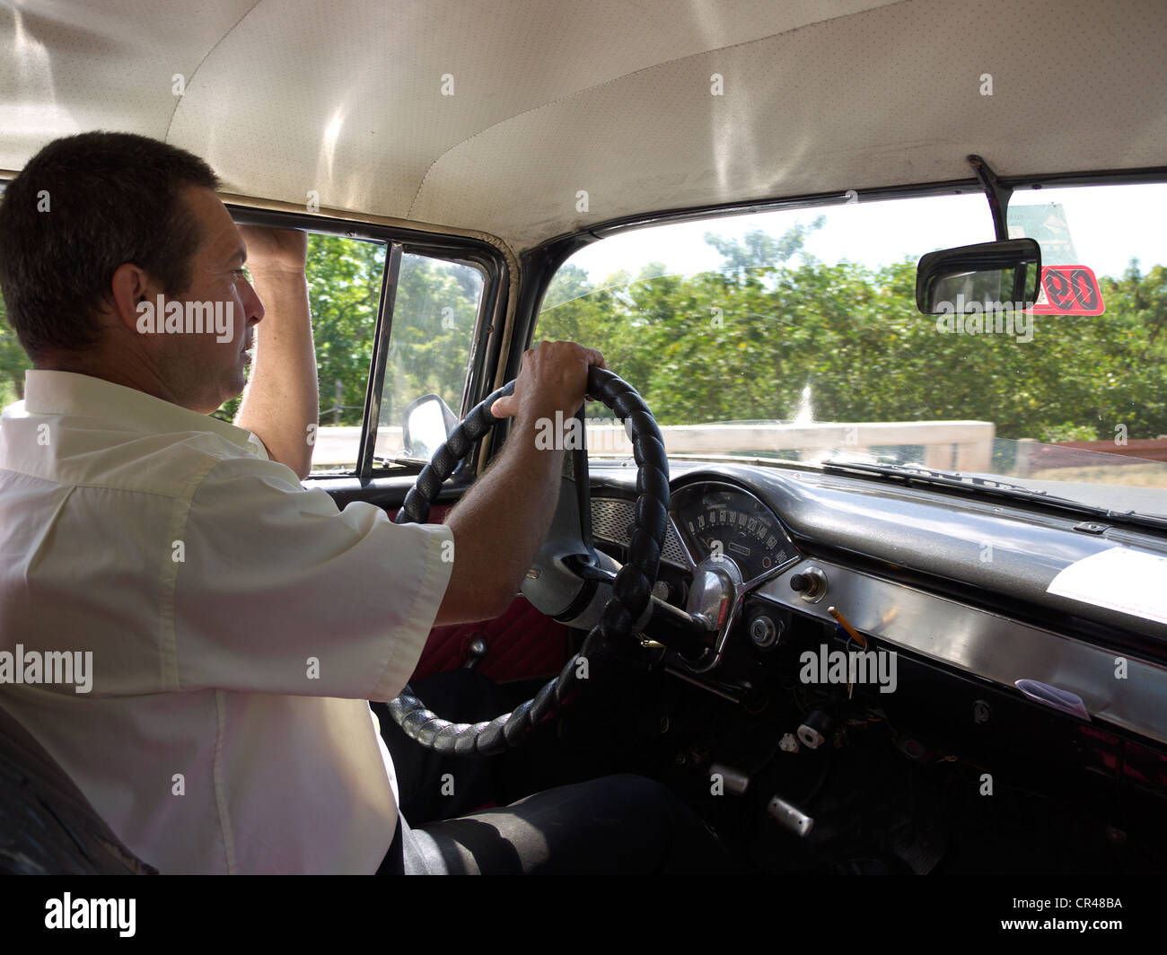 Cuban taxi driver driving his classic car, Trinidad, Cuba, Latin ...