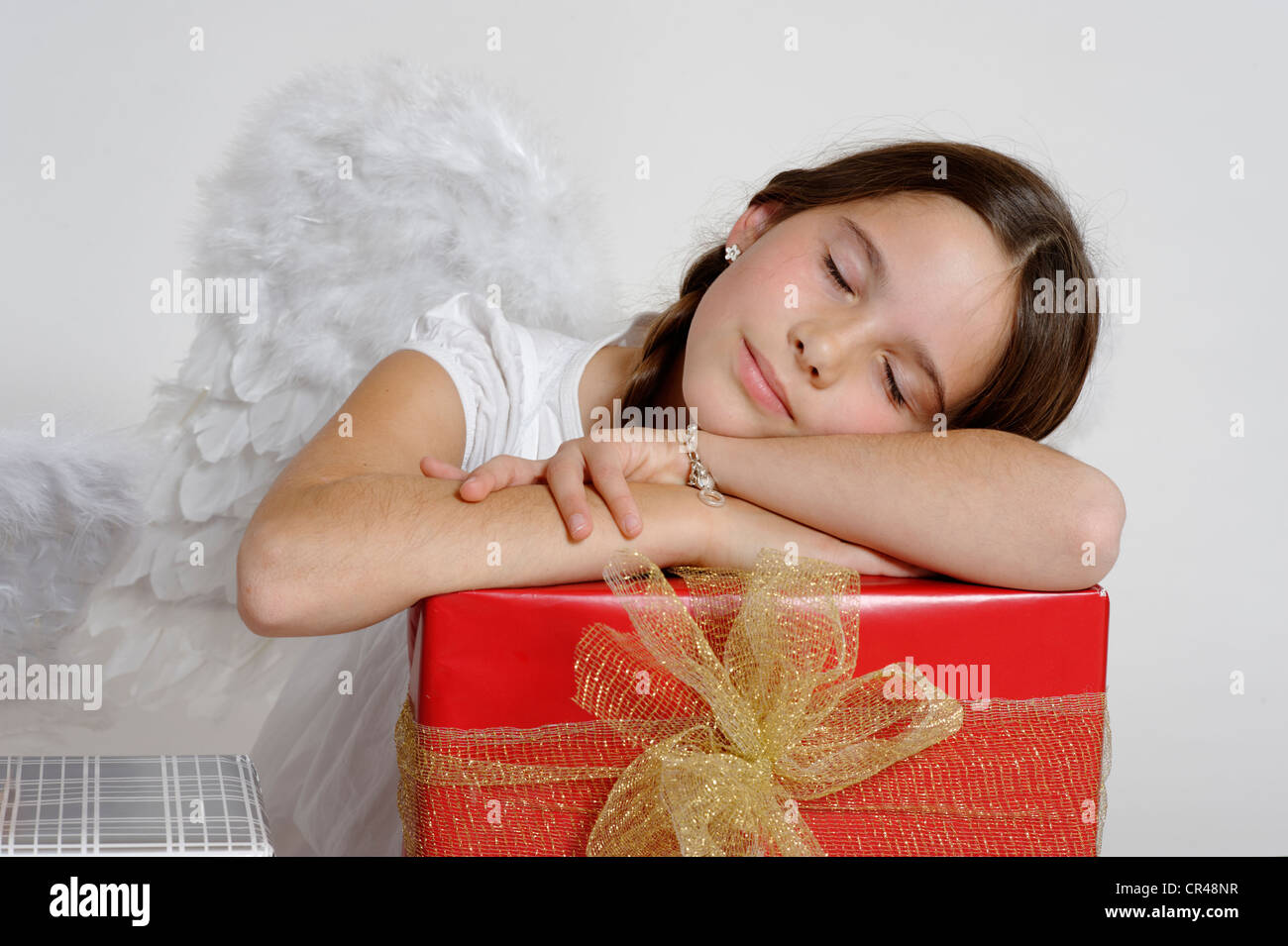 Tired girl dressed up as a Christmas angel with a gift, Christmas Stock ...