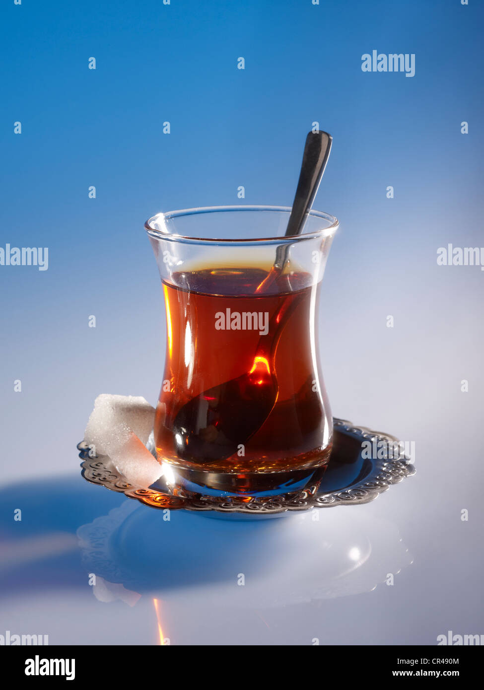 A glass of Turkish tea with sugar cubes and a spoon Stock Photo - Alamy