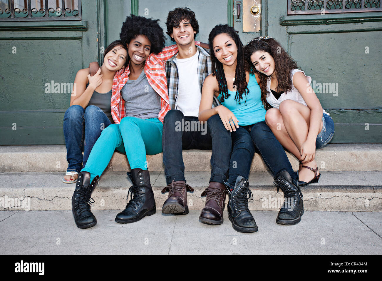 Friends hanging out on front stoop Stock Photo - Alamy