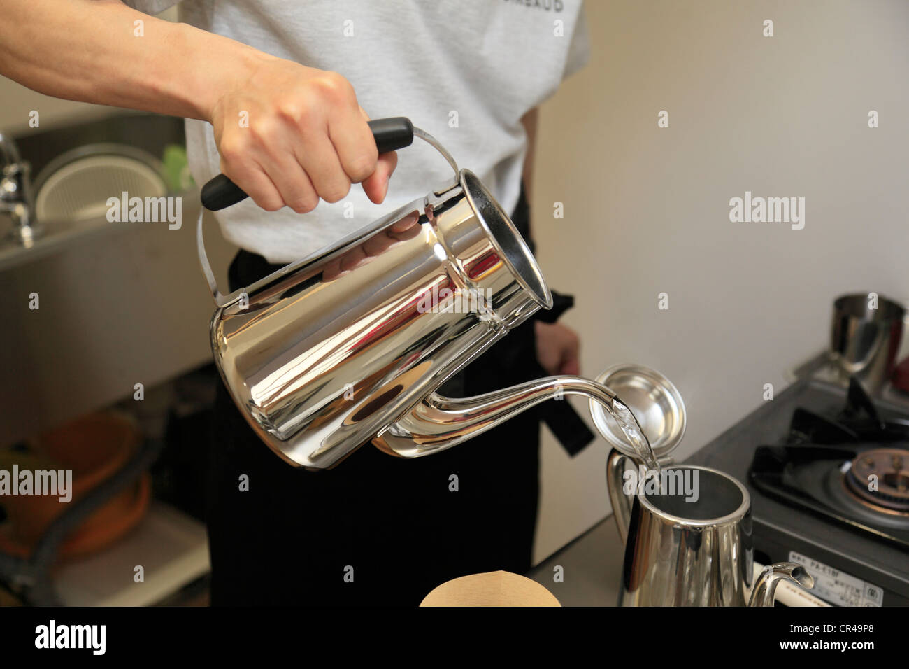Barista Pouring Water from Pot to Pot Stock Photo - Alamy