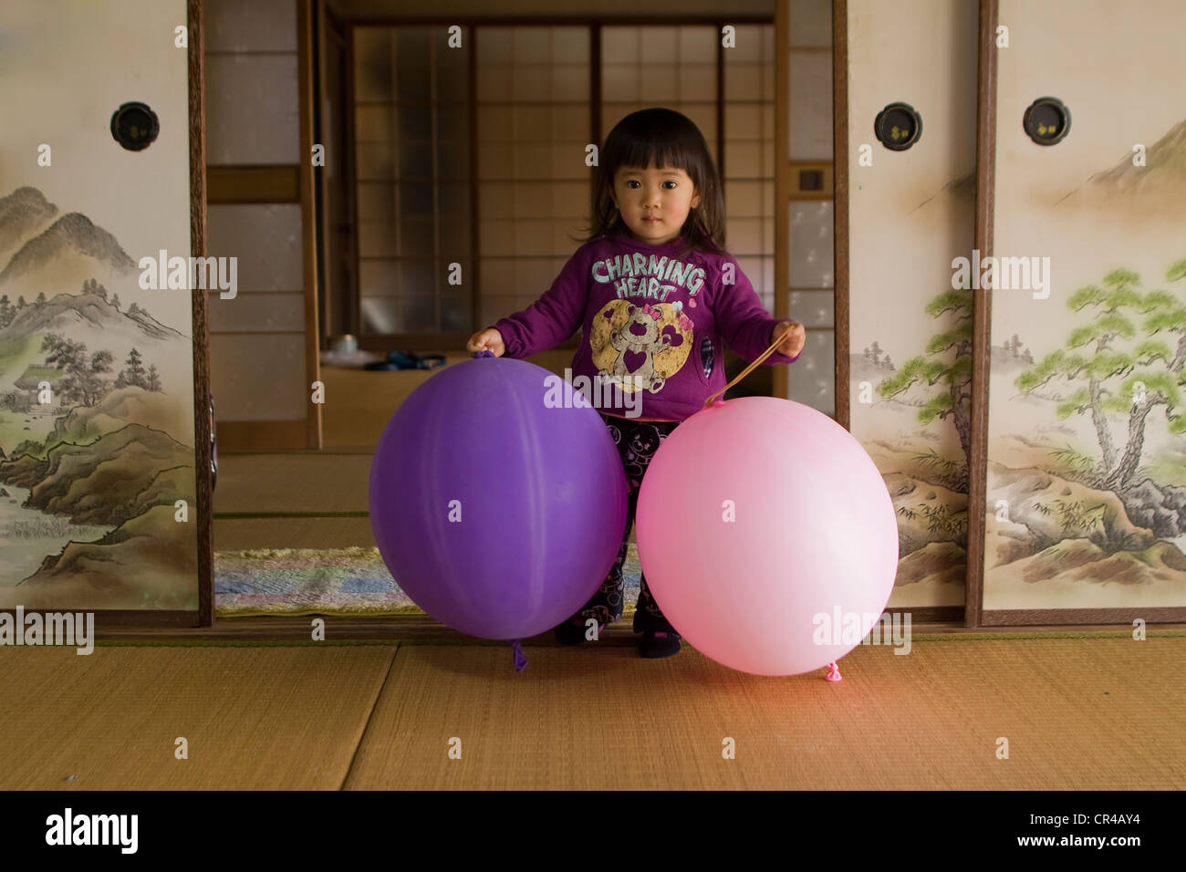 A young Asian girl plays with balloons inside a Japanese home Stock ...