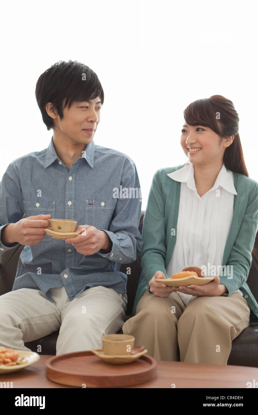 Young Couple Having Tea and Snack Stock Photo - Alamy