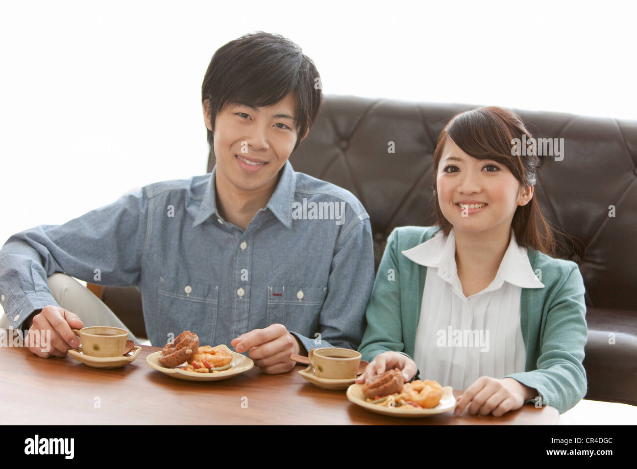 Young Couple Having Tea and Snack Stock Photo - Alamy