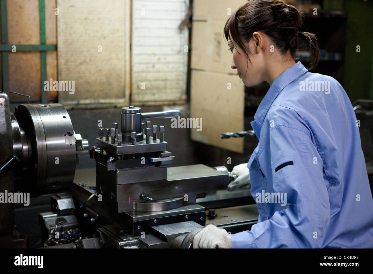 Female Factory Worker Operating Machine Stock Photo - Alamy