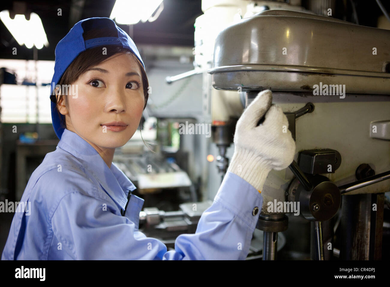 Female Factory Worker Operating Machine Stock Photo - Alamy