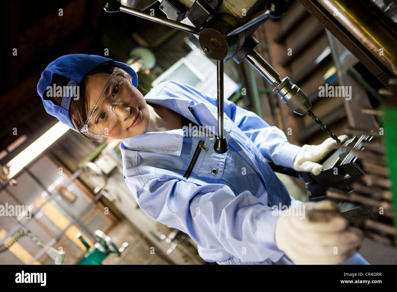 Female Factory Worker Operating Machine Stock Photo - Alamy