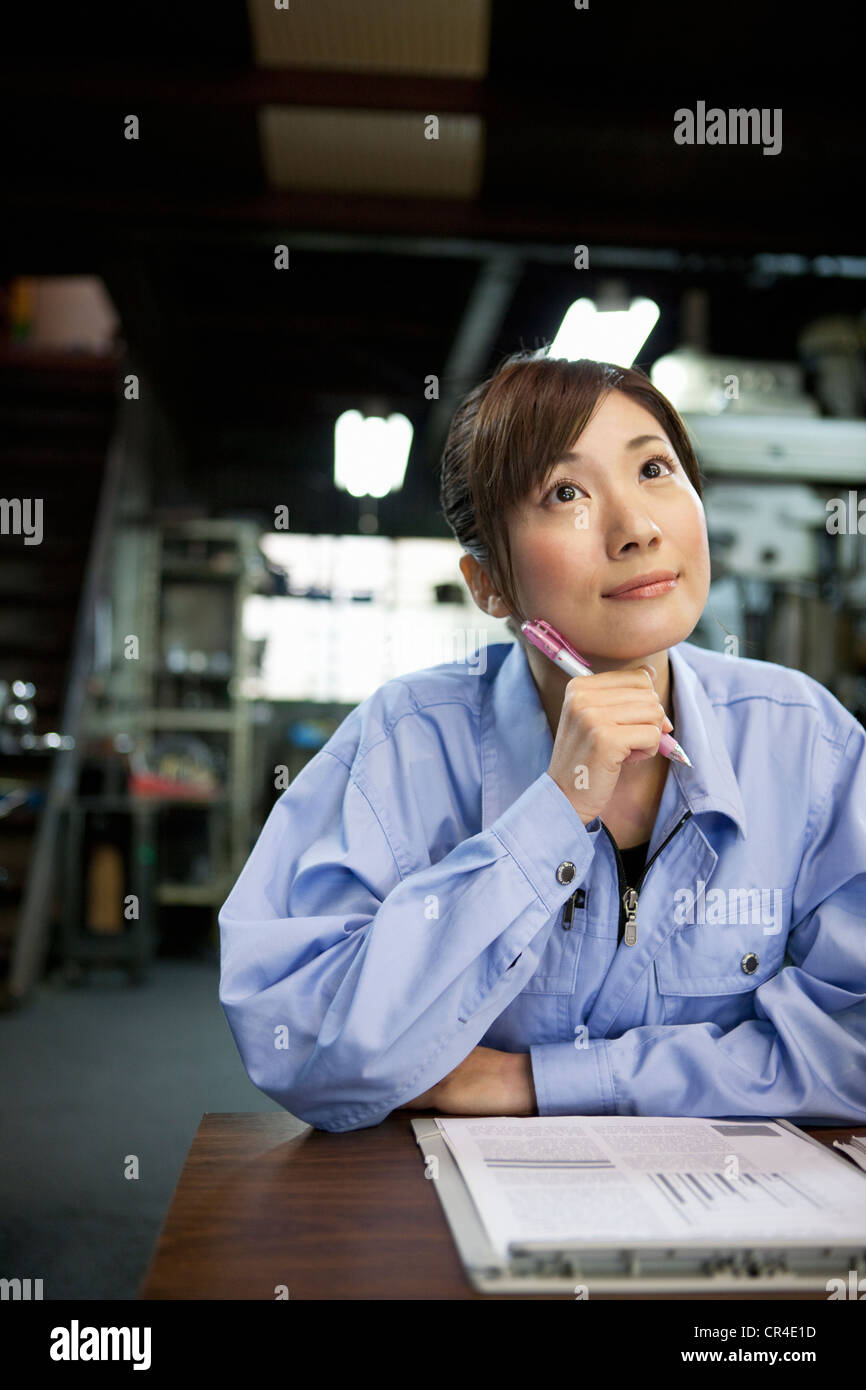Young Female Factory Worker Thinking Stock Photo - Alamy