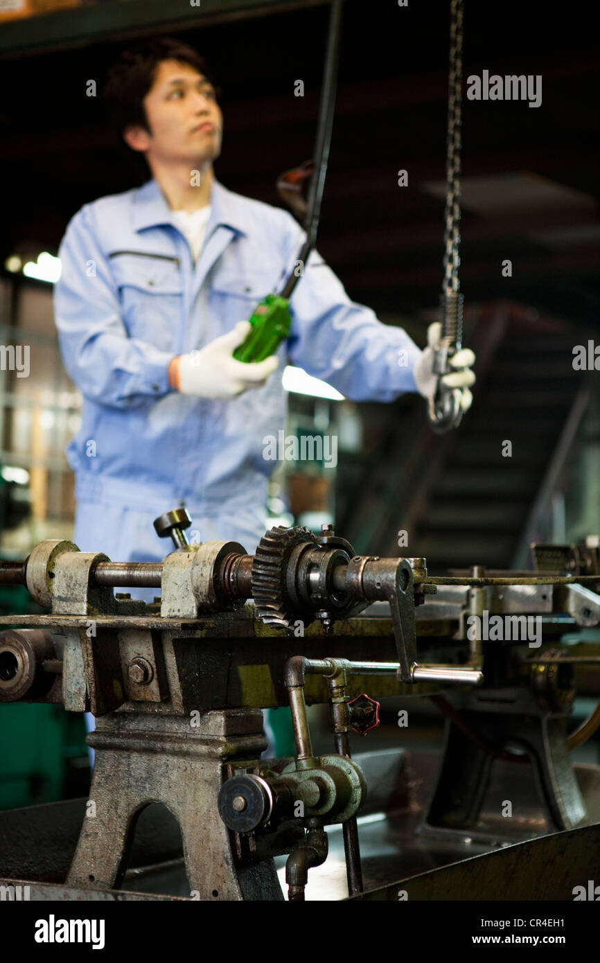Young Man Using Machine In Factory Stock Photo - Alamy