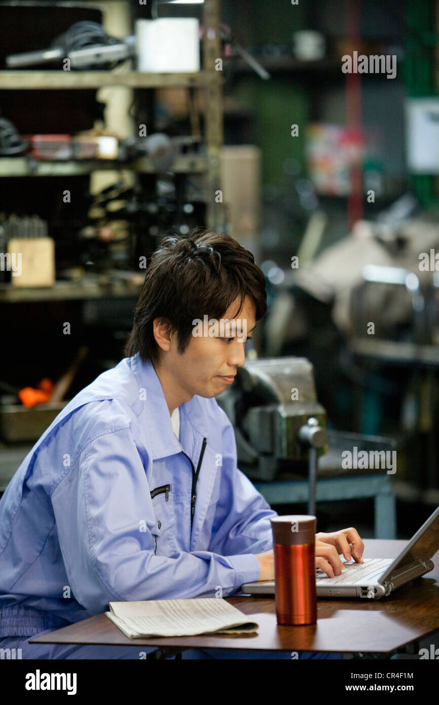 Male Factory Worker Using Laptop Stock Photo - Alamy