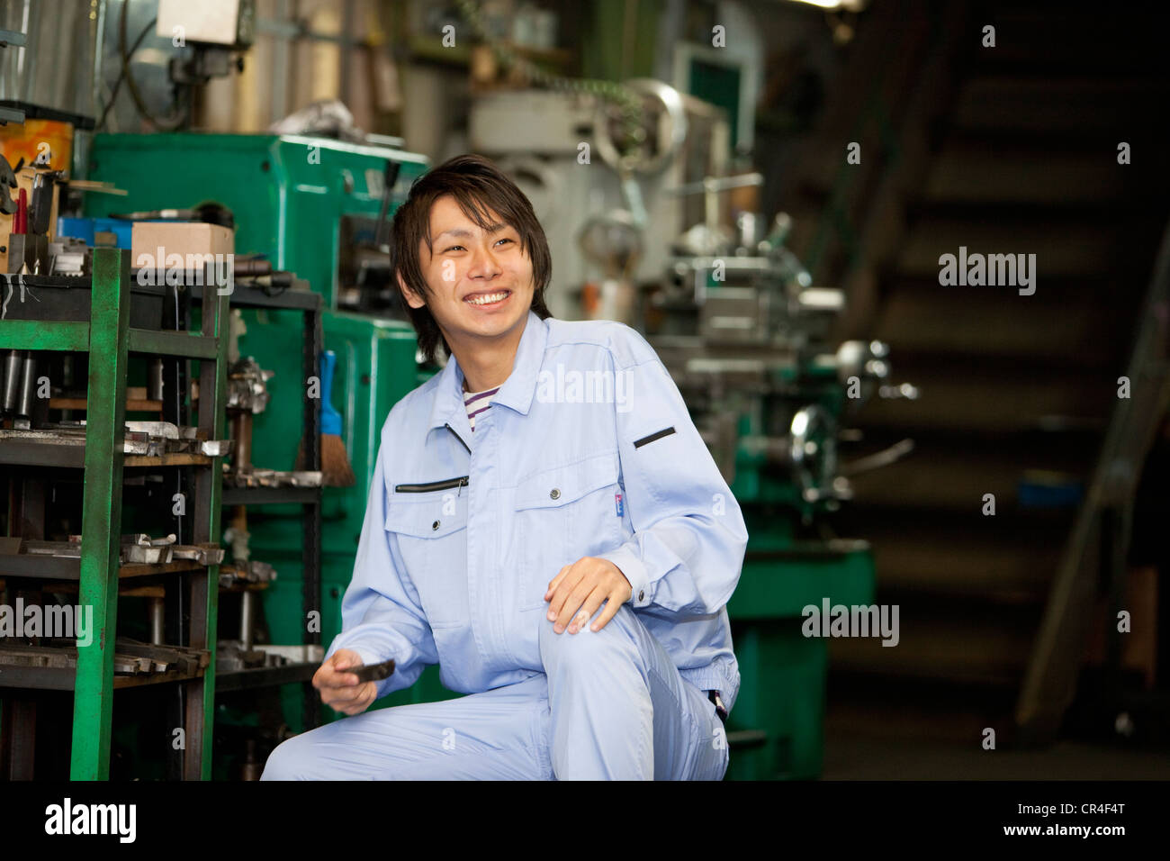 Young Male Factory Worker Sitting By Tools Stock Photo - Alamy