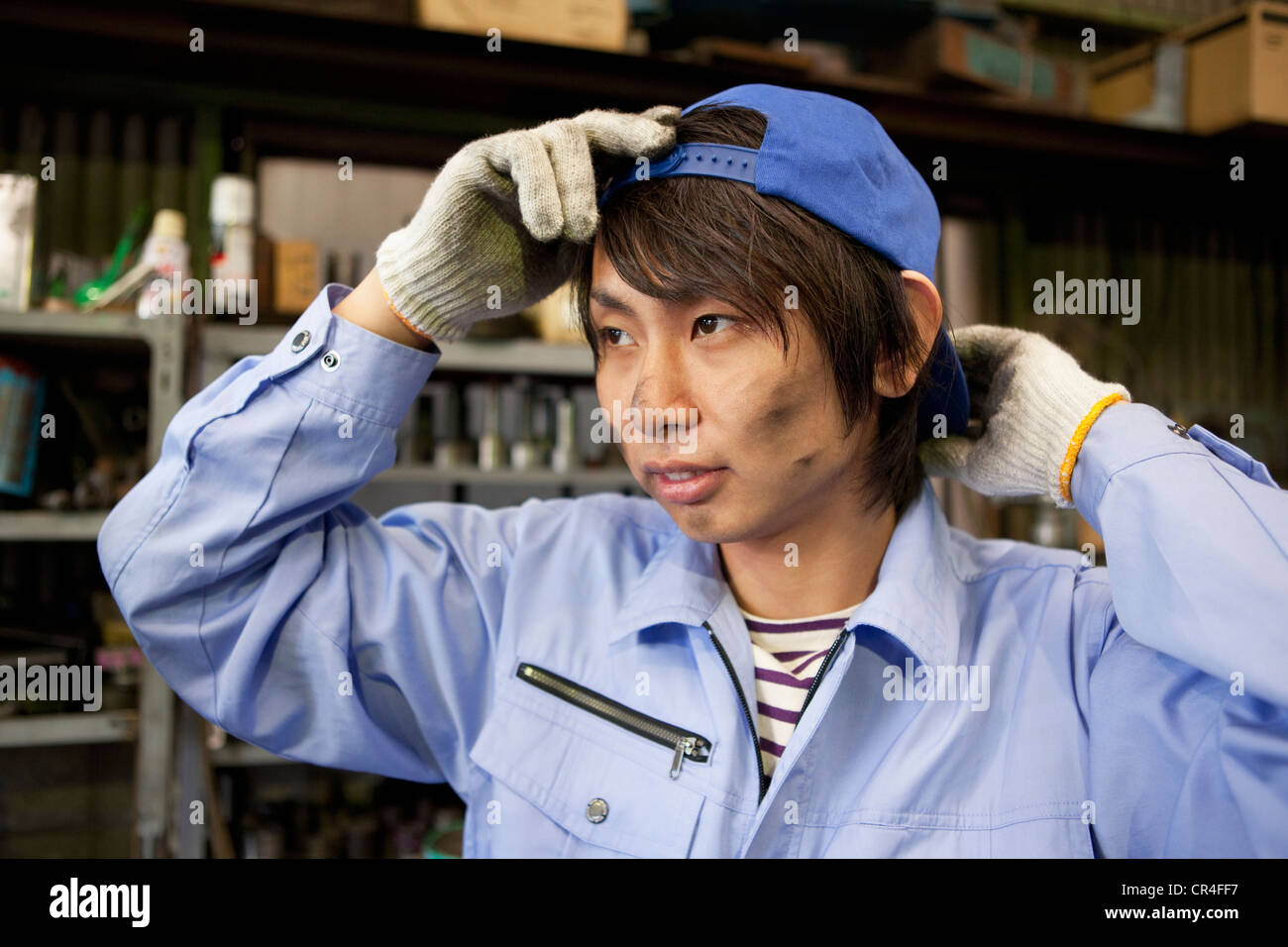 Young Male Factory Worker Putting on Cap Stock Photo - Alamy