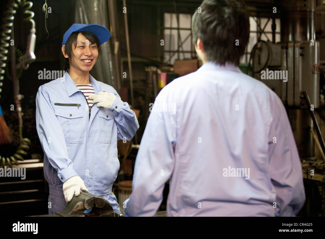 Two Male Factory Workers Talking Stock Photo - Alamy