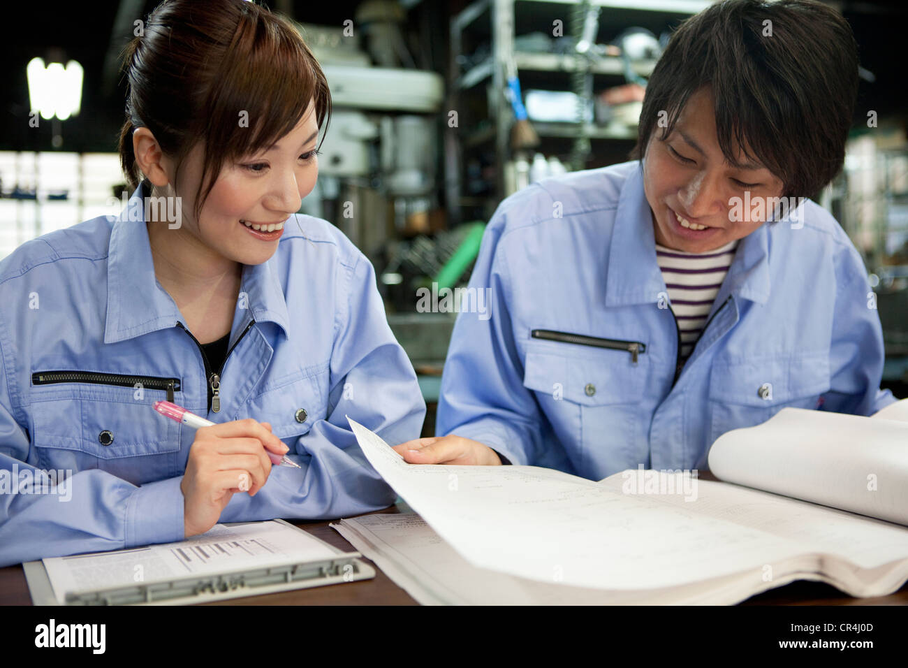 Two Factory Workers Reading Documents Stock Photo - Alamy