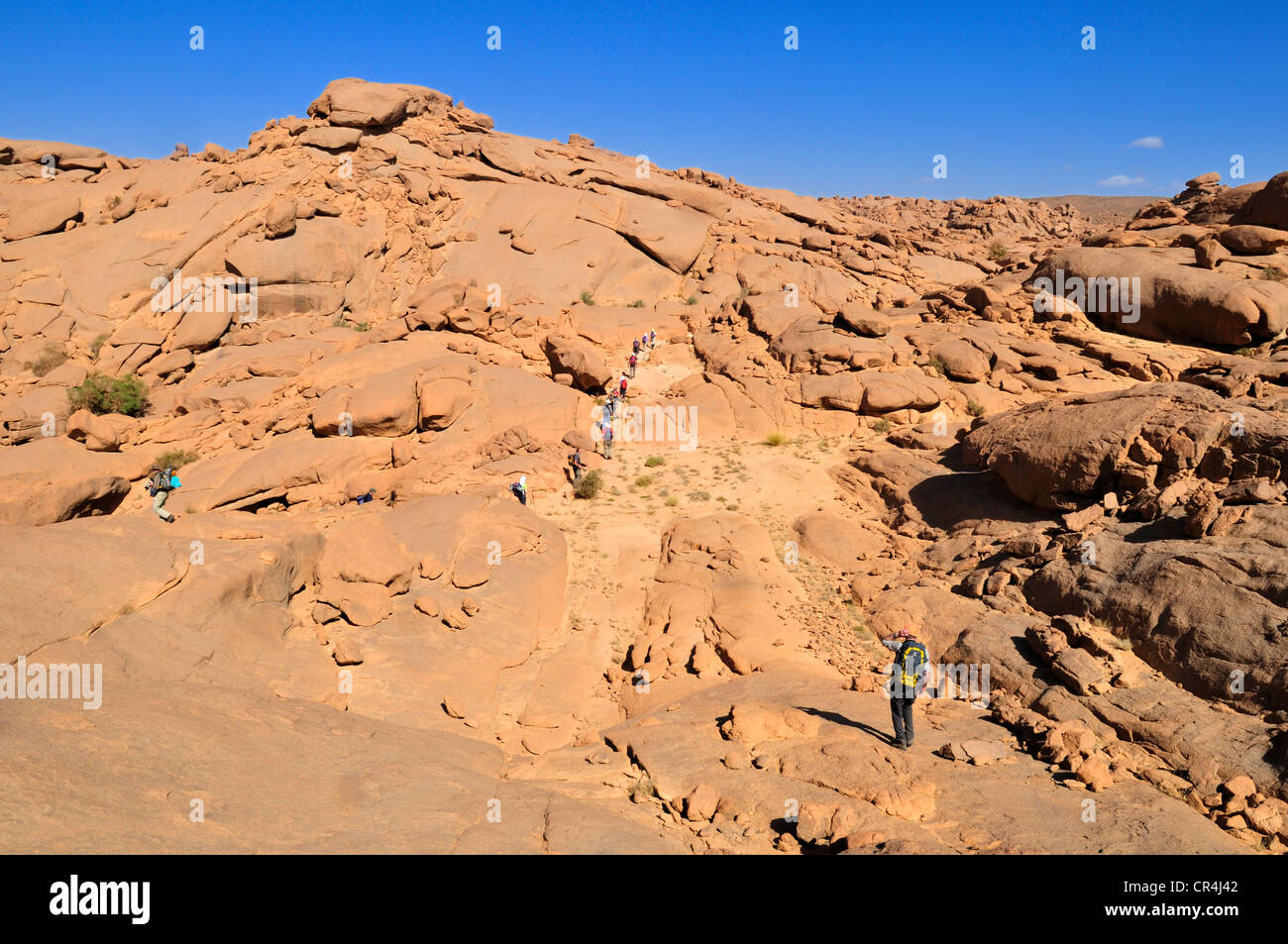 Group of tourists hiking through granite landscape, Hoggar, Ahaggar ...