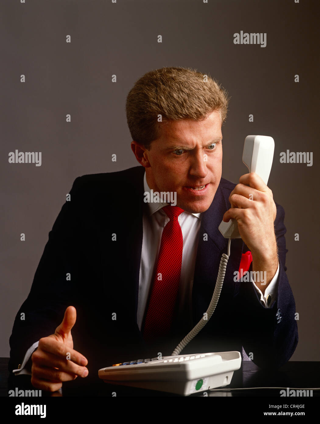 Man looking angrily at telephone Stock Photo - Alamy