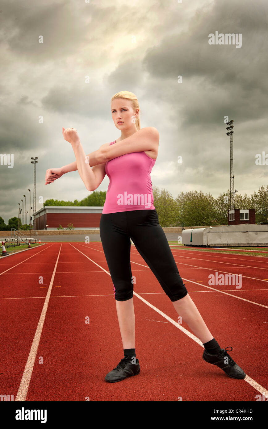 woman stretching arms on the running track Stock Photo - Alamy