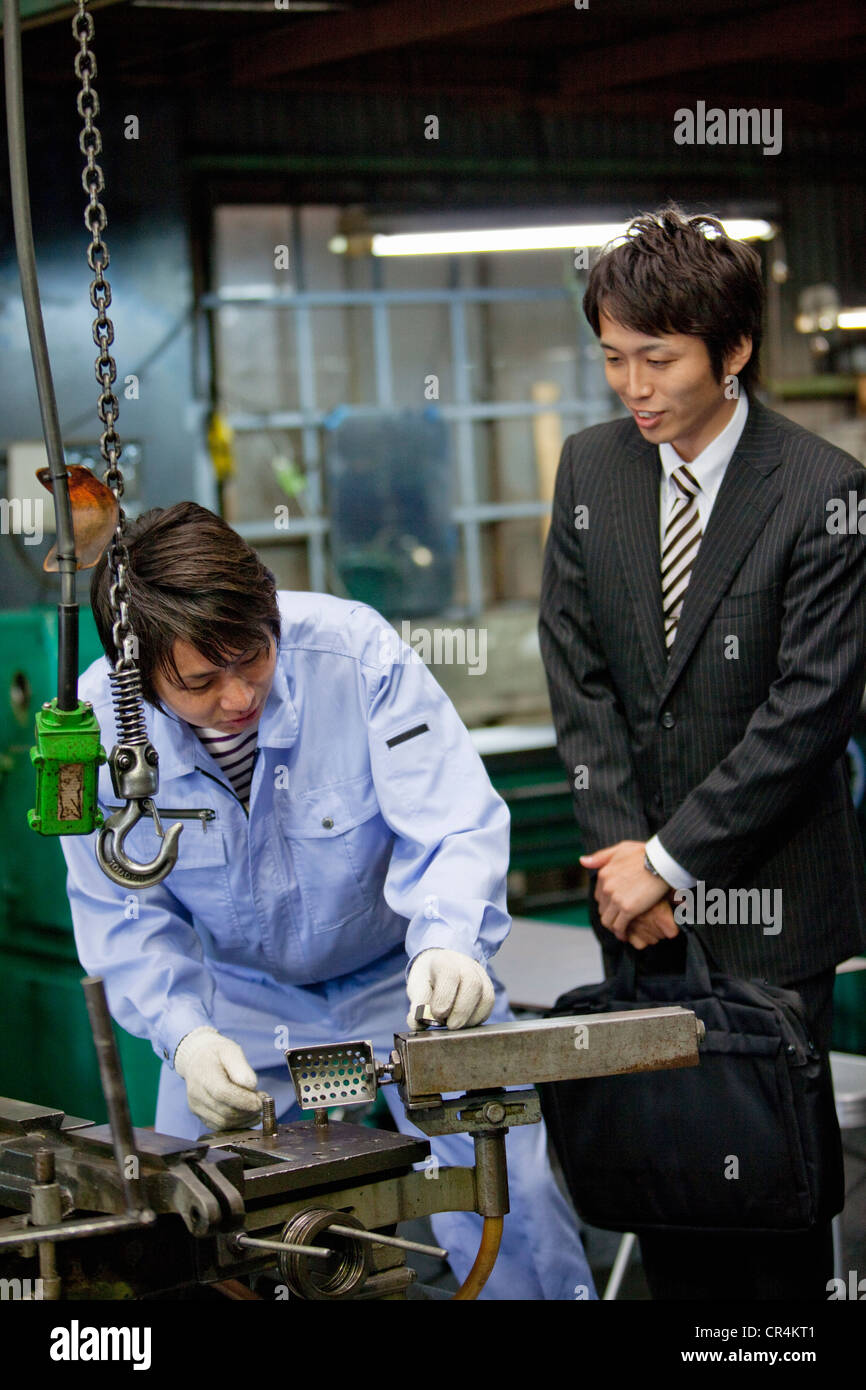 Salesman Watching Worker Operating Machine Stock Photo - Alamy
