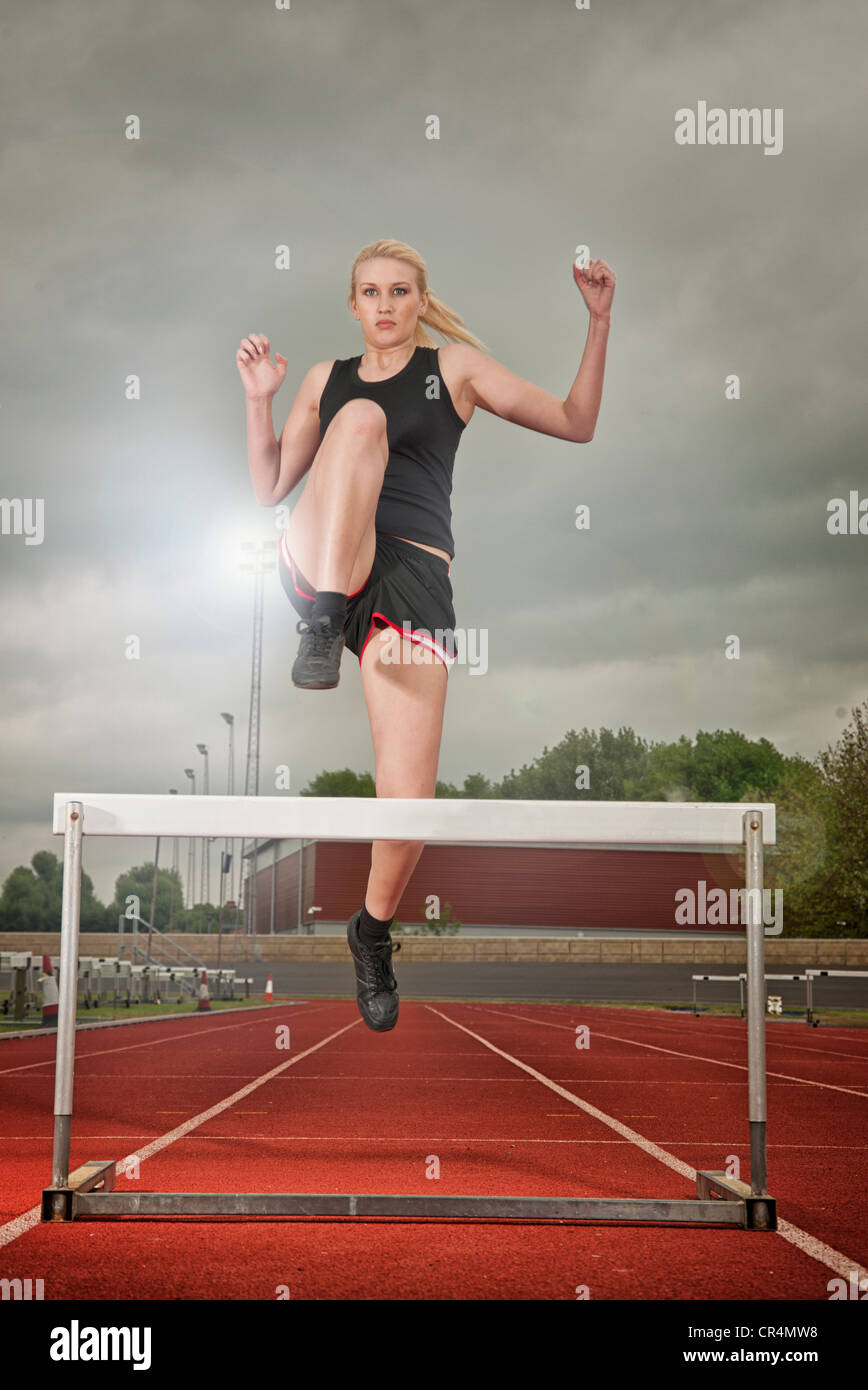 woman jumping a hurdle Stock Photo - Alamy