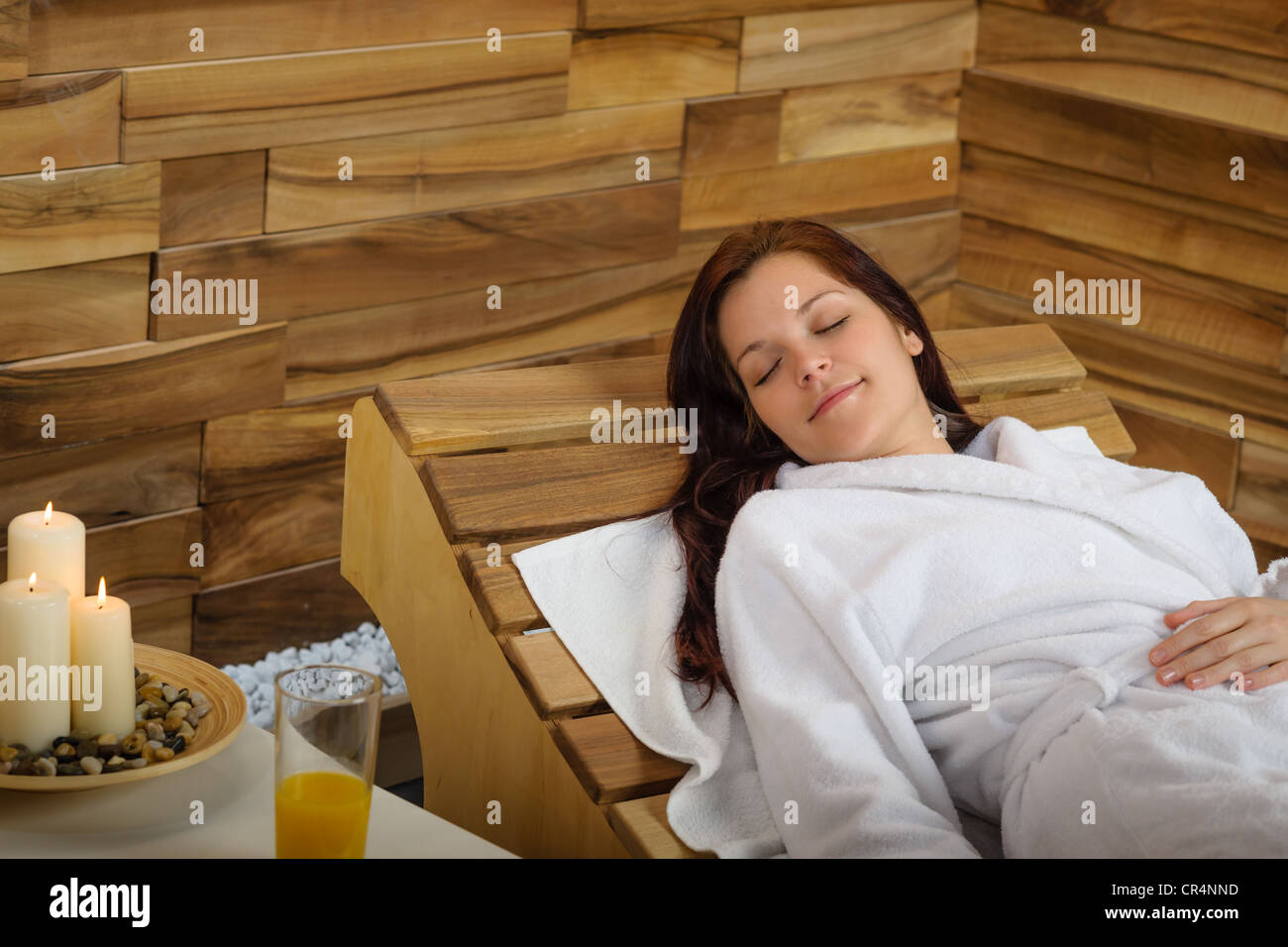 Young woman relaxing on wooden chair at luxury spa Stock Photo - Alamy