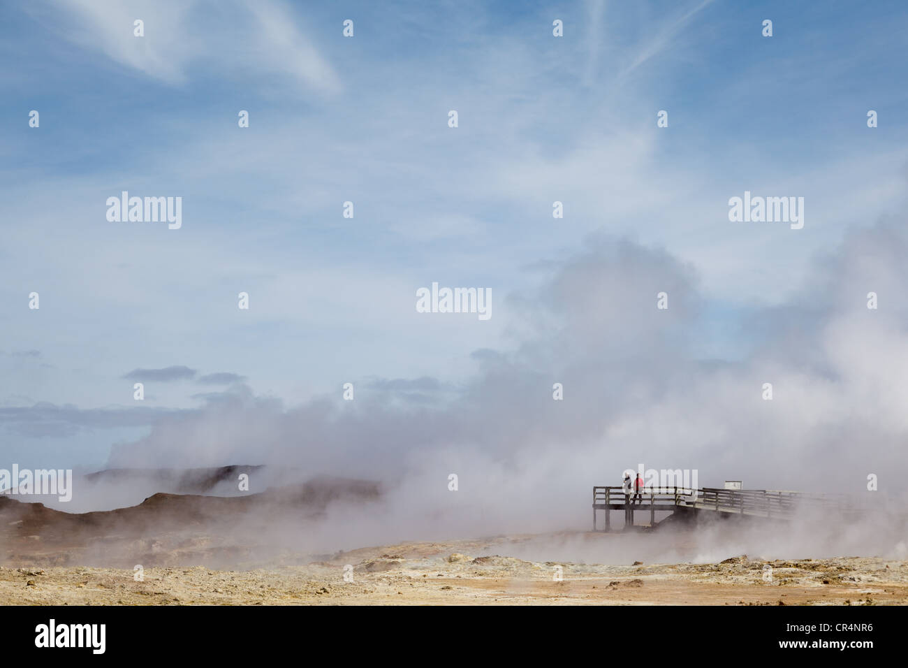 Tourists watch geothermal steam rising from the ground at Svartsengi ...