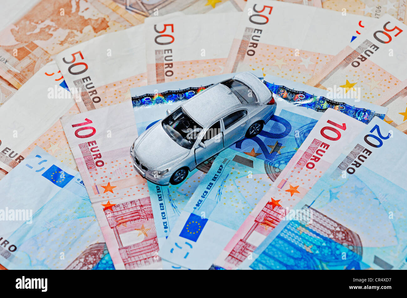 Toy car on euro banknotes Stock Photo - Alamy