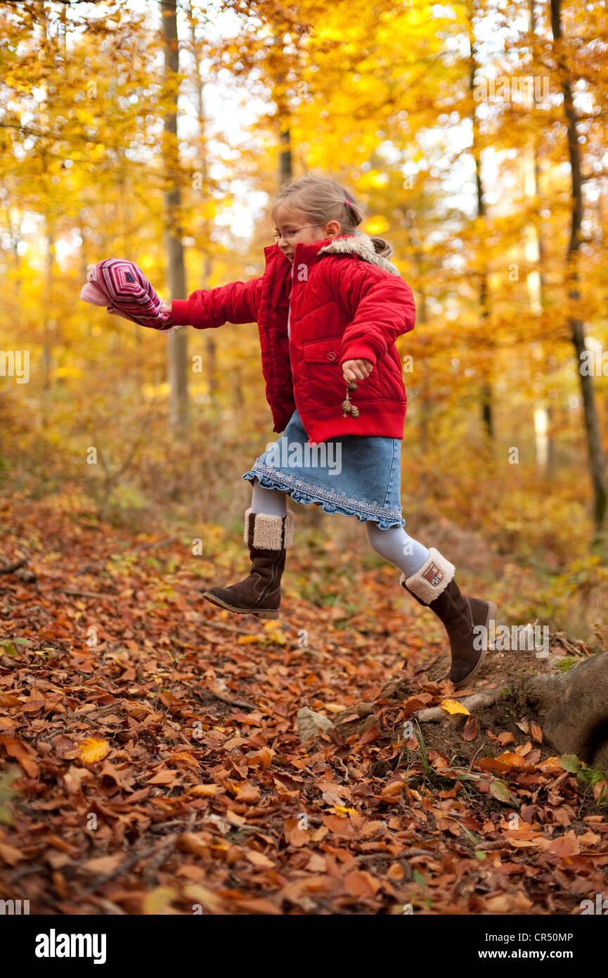 Girl, 5 years, jumping from a tree stump in the autumn forest Stock ...