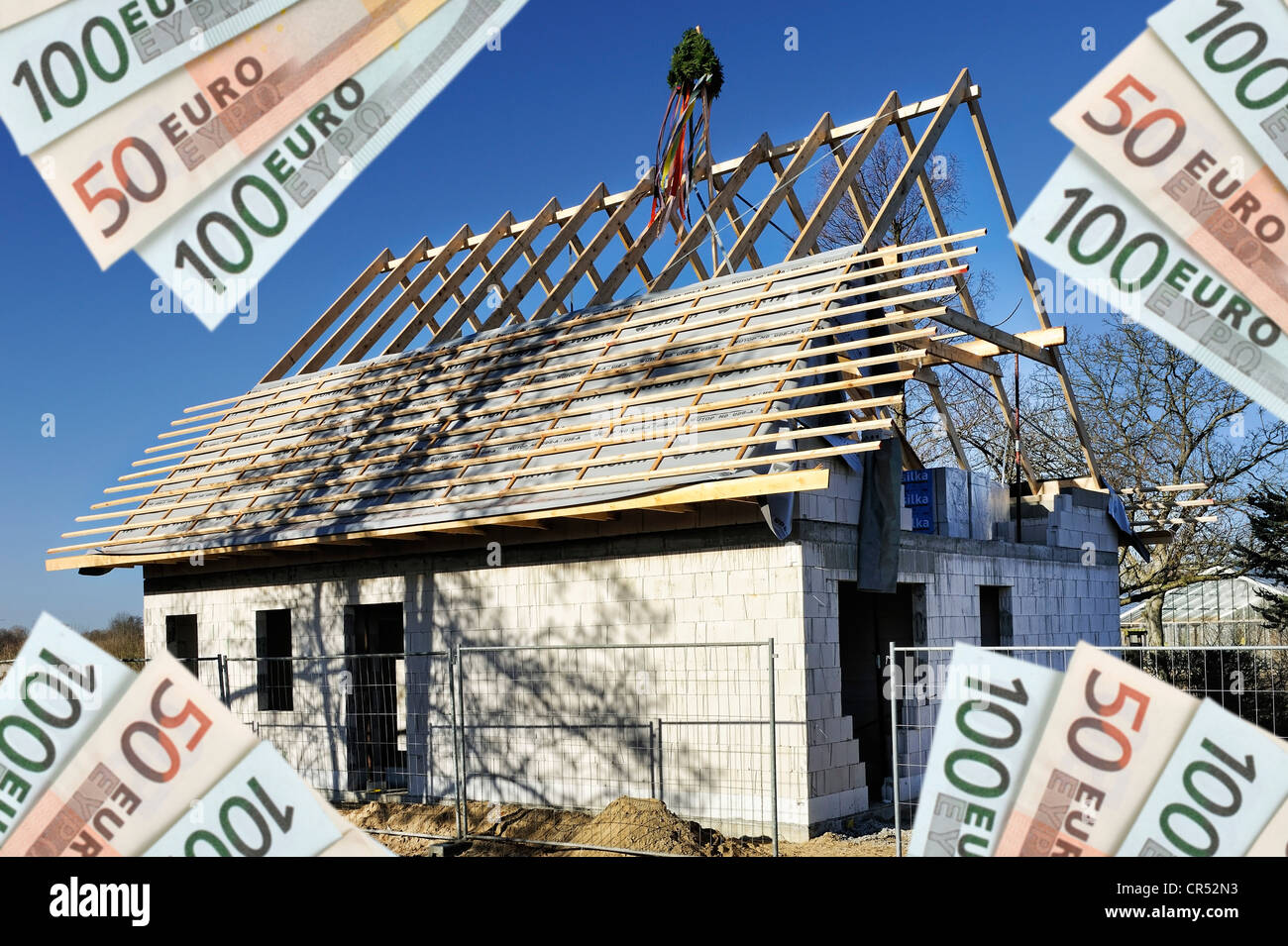 Euro banknotes in front of a house under construction, symbolic image ...