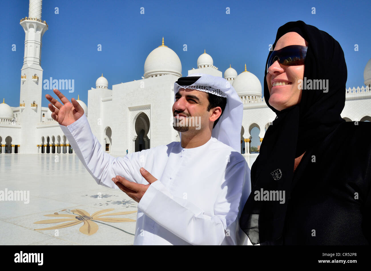 Local man giving veiled tourist a tour of the Sheikh Zayed Mosque, Abu ...