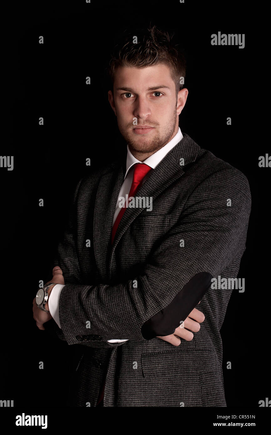Young man wearing a suit, with arms crossed Stock Photo - Alamy