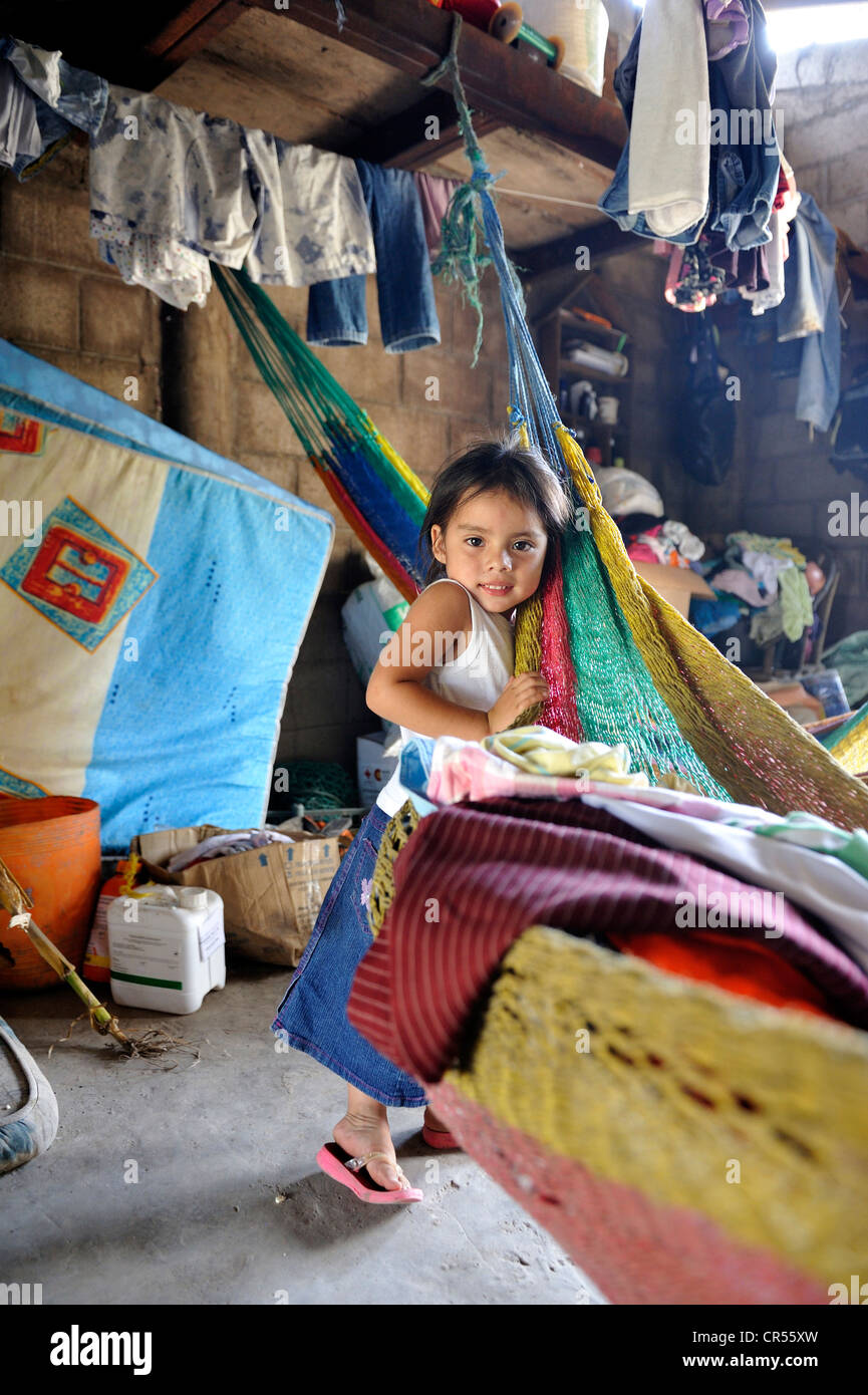 Girl standing in a simple and disorderly house, El Angel, Bajo Lempa ...