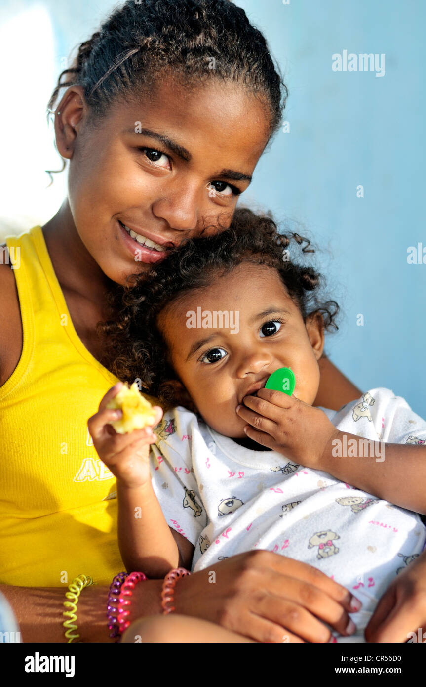 Young girl with a baby, slum district of Favela Morro da Formiga ...