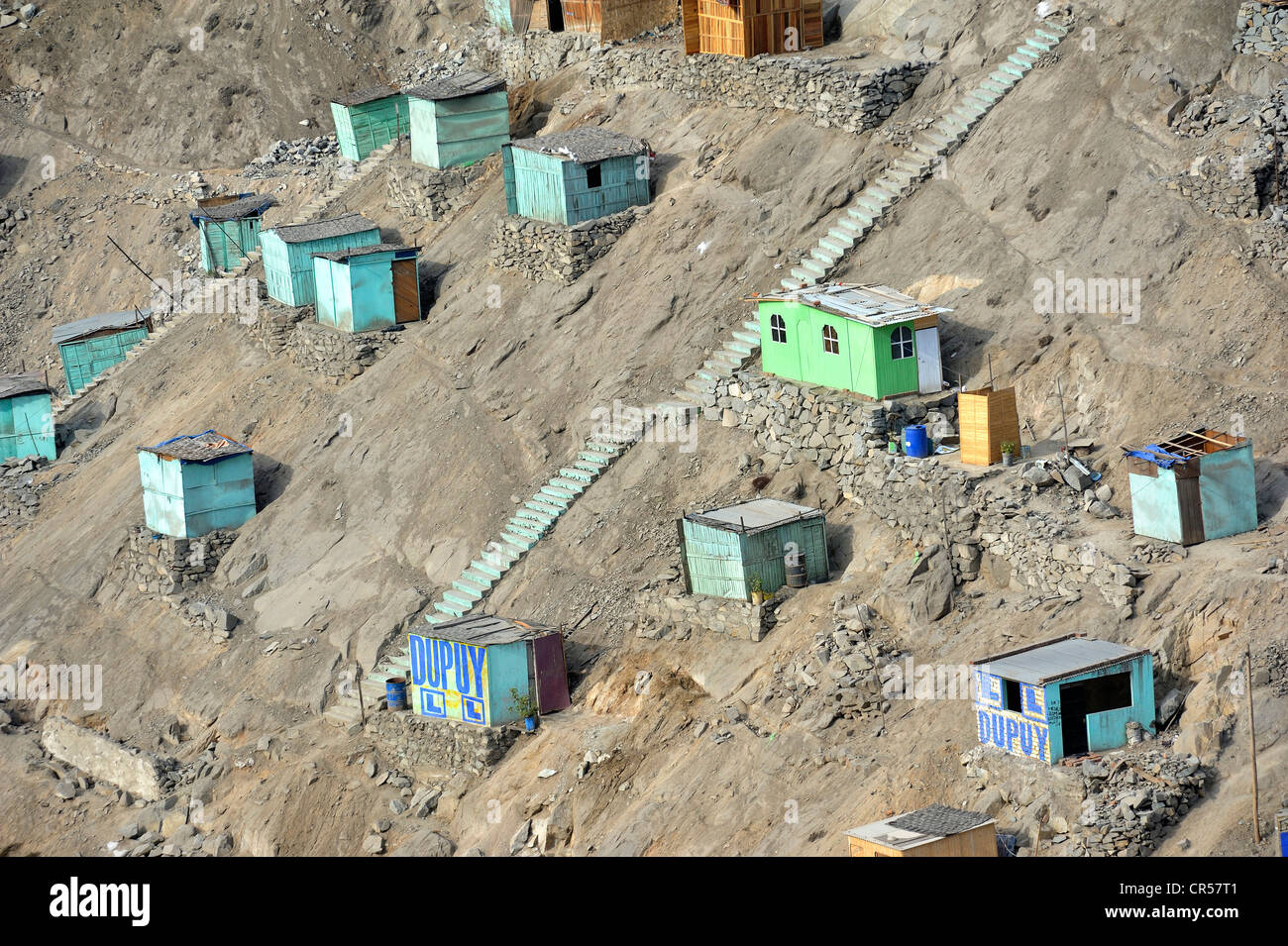 Brightly painted wooden houses built on sandy slopes in the dry desert ...