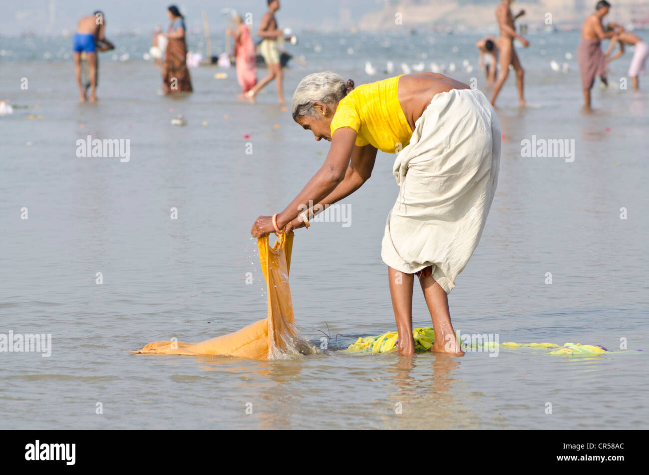 Pilgrim washing clothes at the Sangam, the confluence of the holy ...