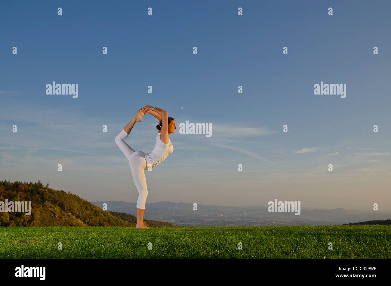 Young woman practising Hatha yoga outdoors, showing the pose ...