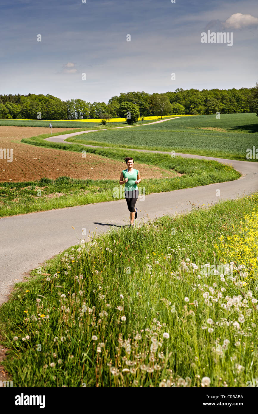 A woman jogging in front of cross country Stock Photo - Alamy