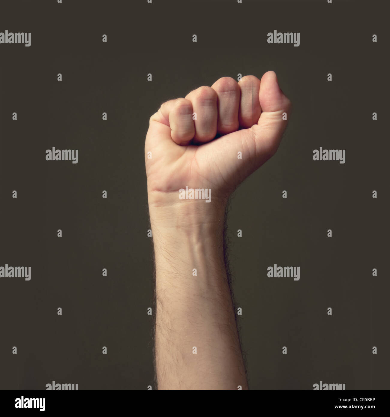 Male fist raised high in the air in a low light environment Stock Photo ...