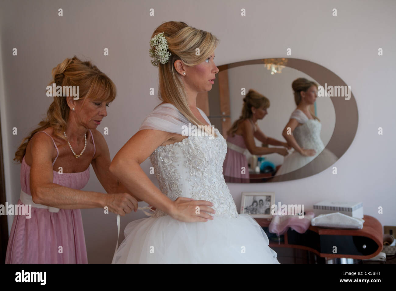 The mother is dressing the bride Stock Photo - Alamy