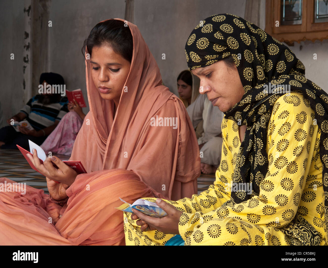 Two Sikh ladies reciting texts from the holy scriptures, Amritsar ...